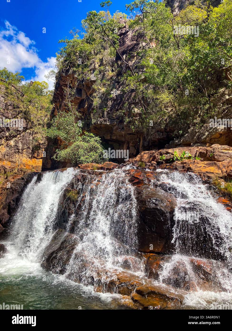 The majestic Cachoeira Macaquinhos waterfall cascades into a green pool ...