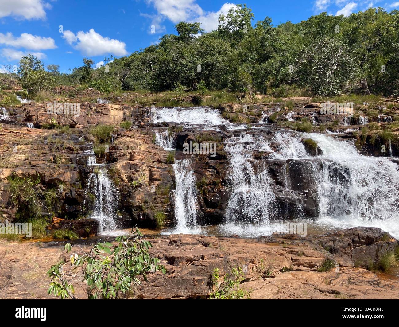 The majestic Cachoeira Macaquinhos waterfall cascades into a green pool ...