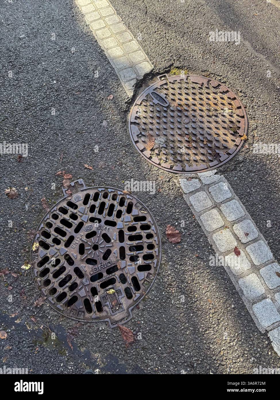 Rusty Manhole Covers on Asphalt Road Stock Photo - Alamy