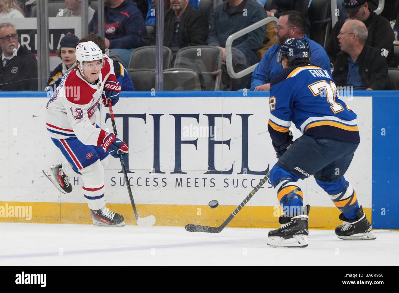 Montreal Canadiens' Cole Caufield (13) passes around St. Louis Blues ...