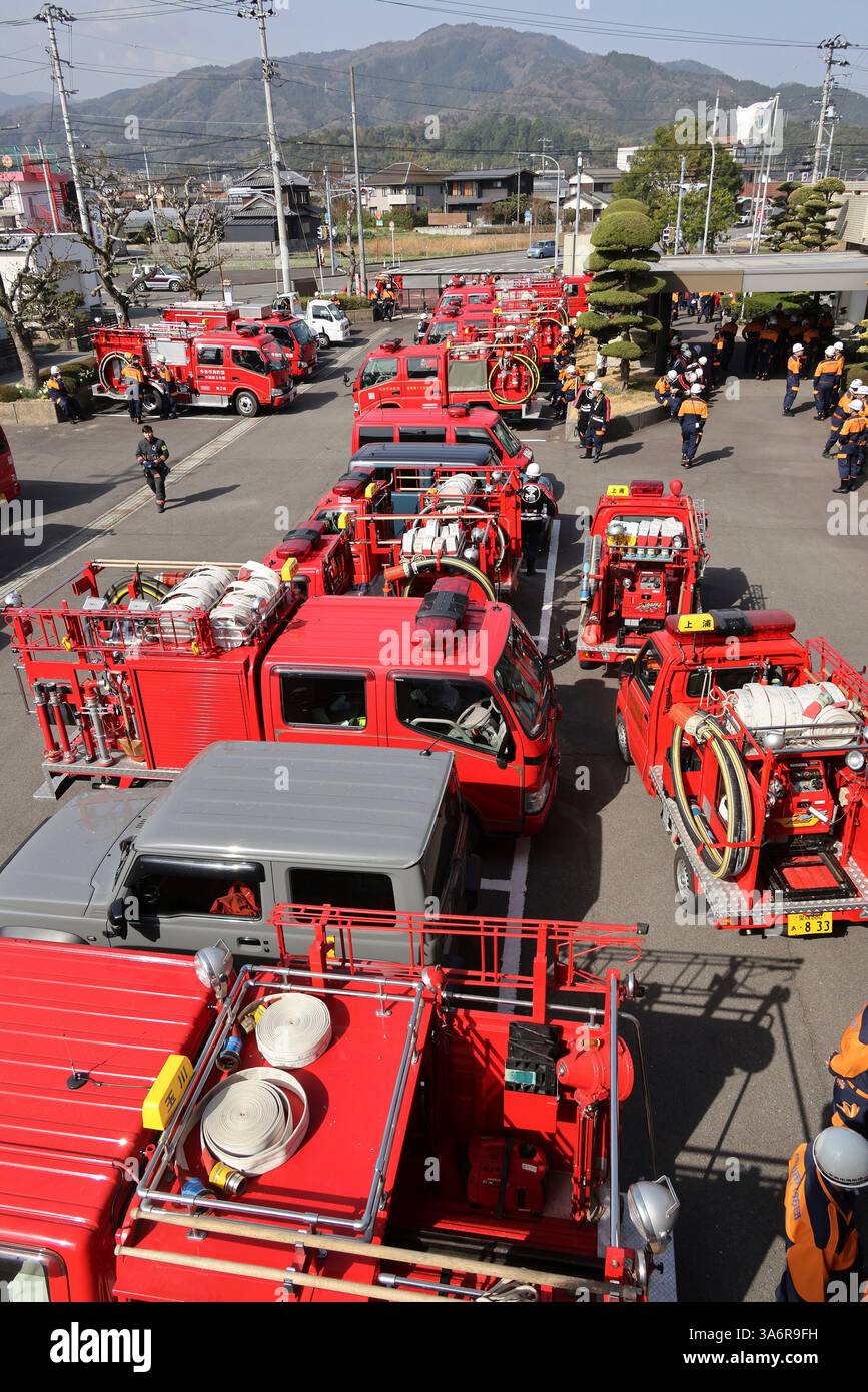Firefighters and fire engines gather to put out a spreading forest fire ...