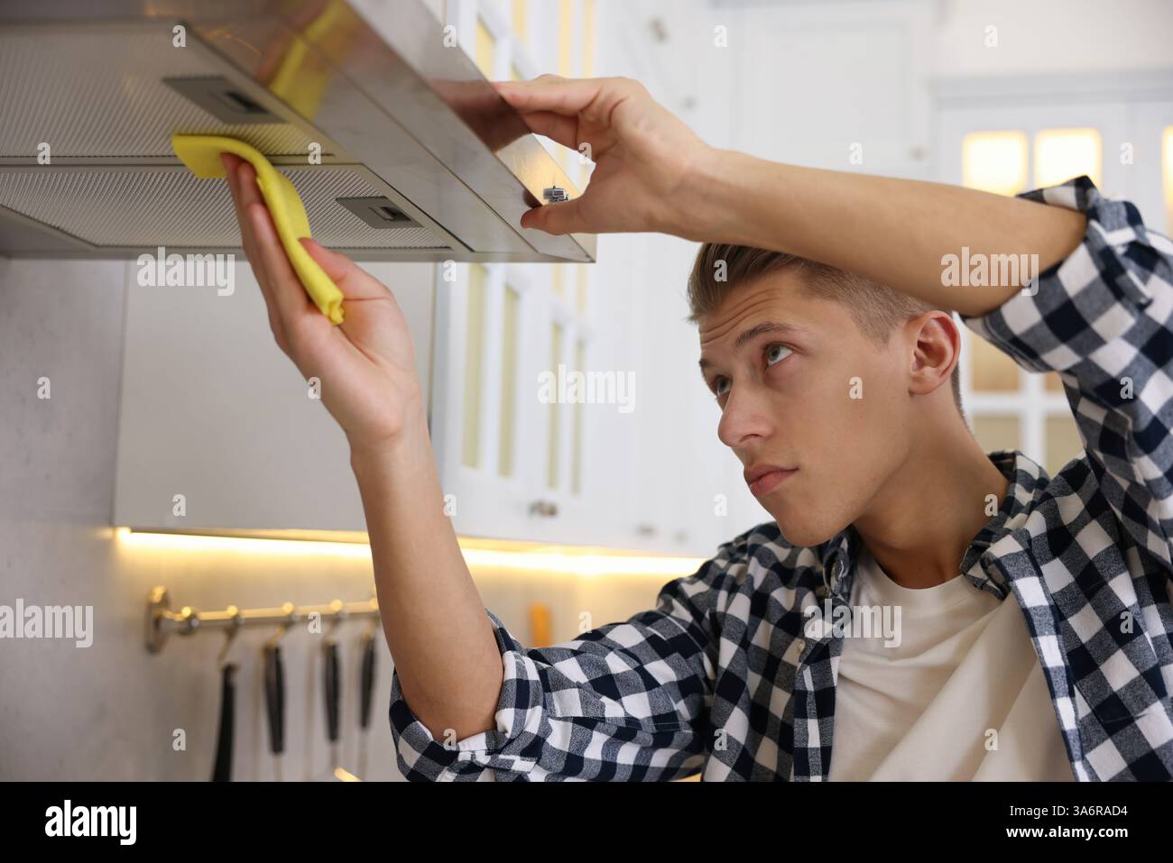 Man cleaning kitchen hood with rag at home Stock Photo - Alamy