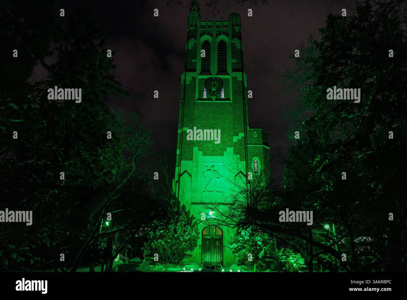 Beaumont Tower is illuminated in green as community members leave ...
