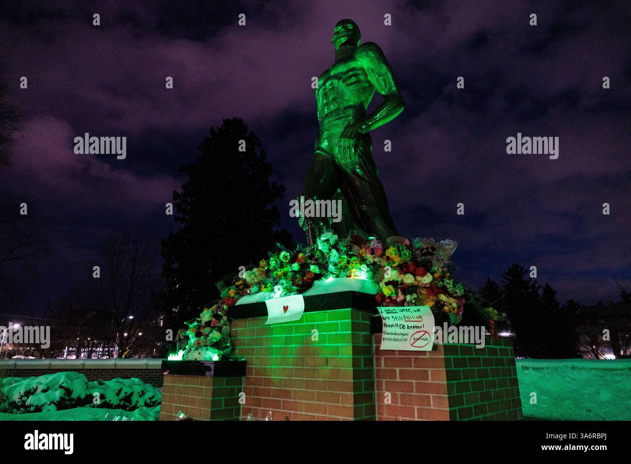 East Lansing, USA. 13th Feb, 2025. Community members leave flowers and ...