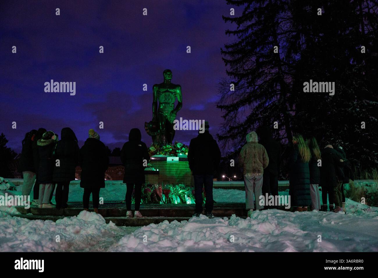 Community members leave flowers and luminaries at the Spartan Statue on ...