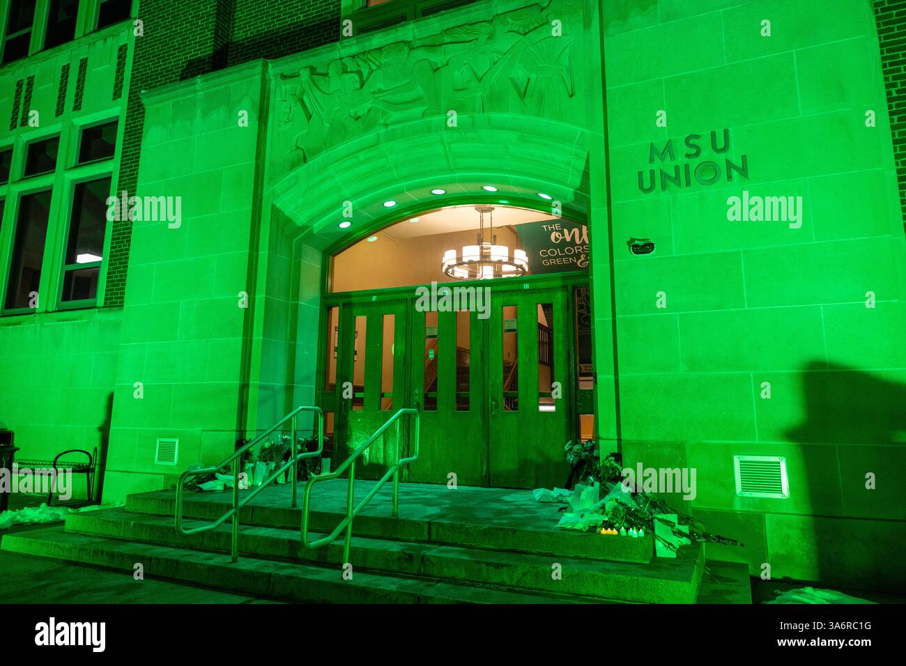 The MSU Union is illuminated in green as community members leave ...