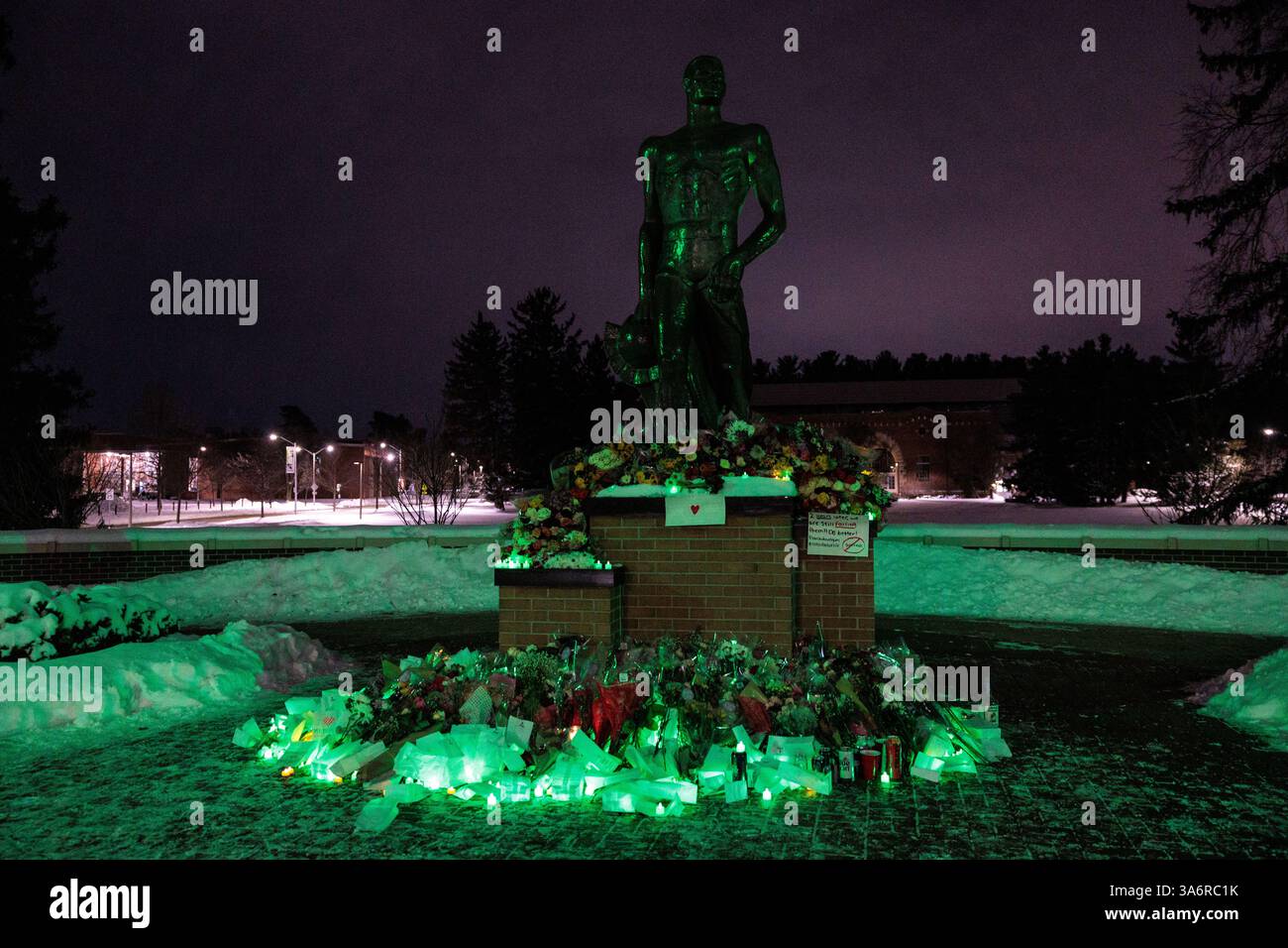 East Lansing, USA. 13th Feb, 2025. Community members leave flowers and ...