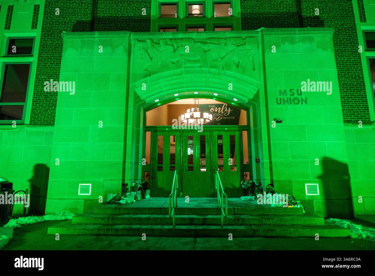 The MSU Union is illuminated in green as community members leave ...