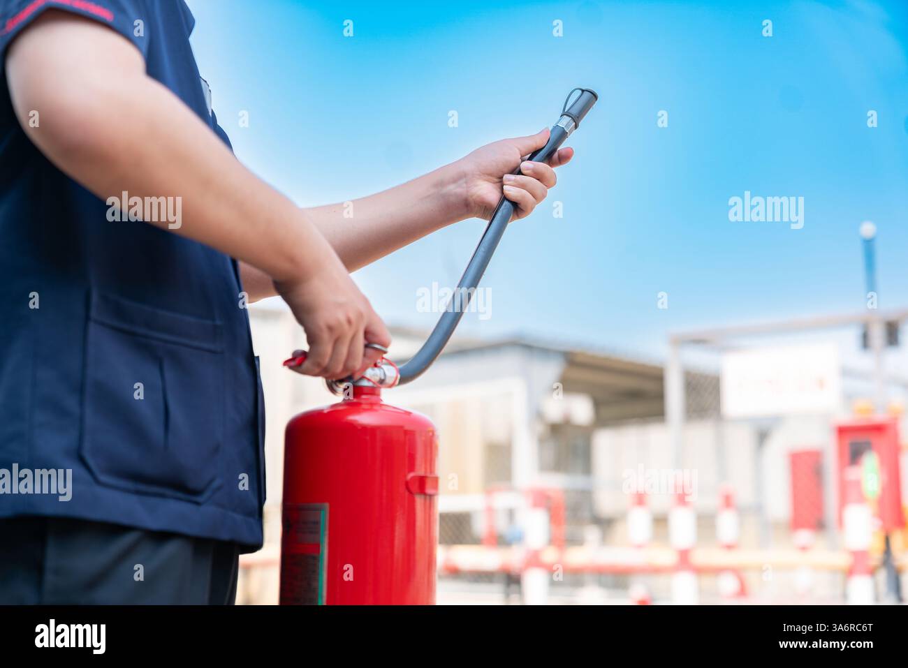 The man is pulling the safety pin and pressing the trigger of the fire ...