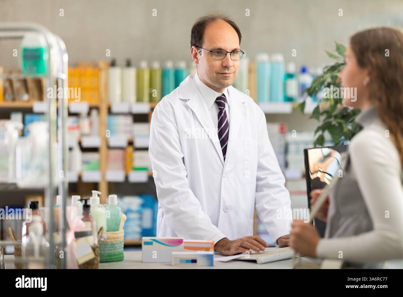 Male pharmacist and female customer search for drug name online ...