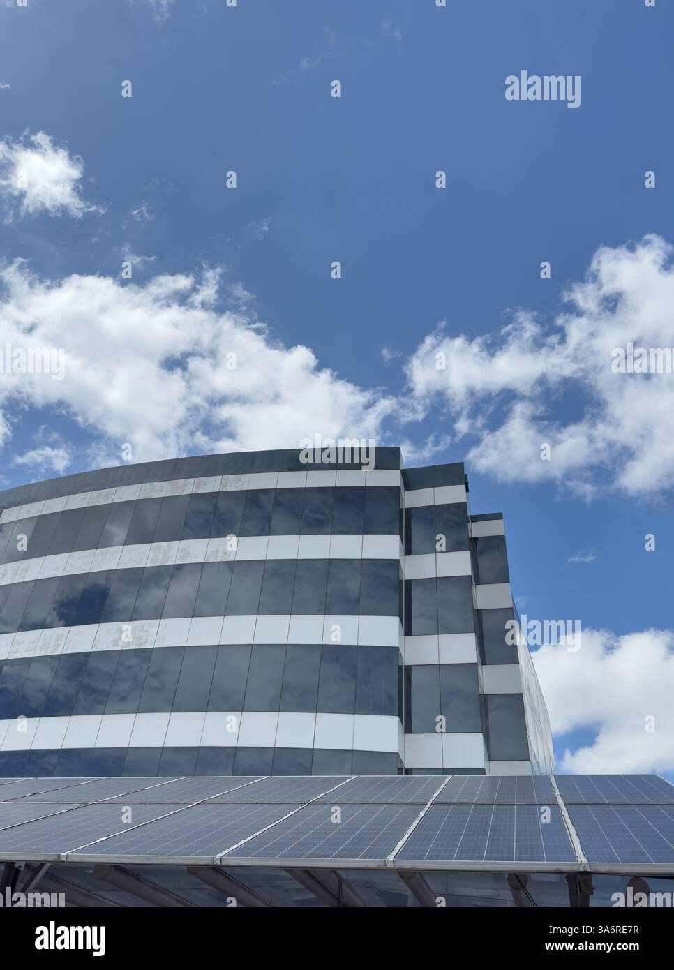 Sleek, modern building highlights solar panels on its roof beneath ...