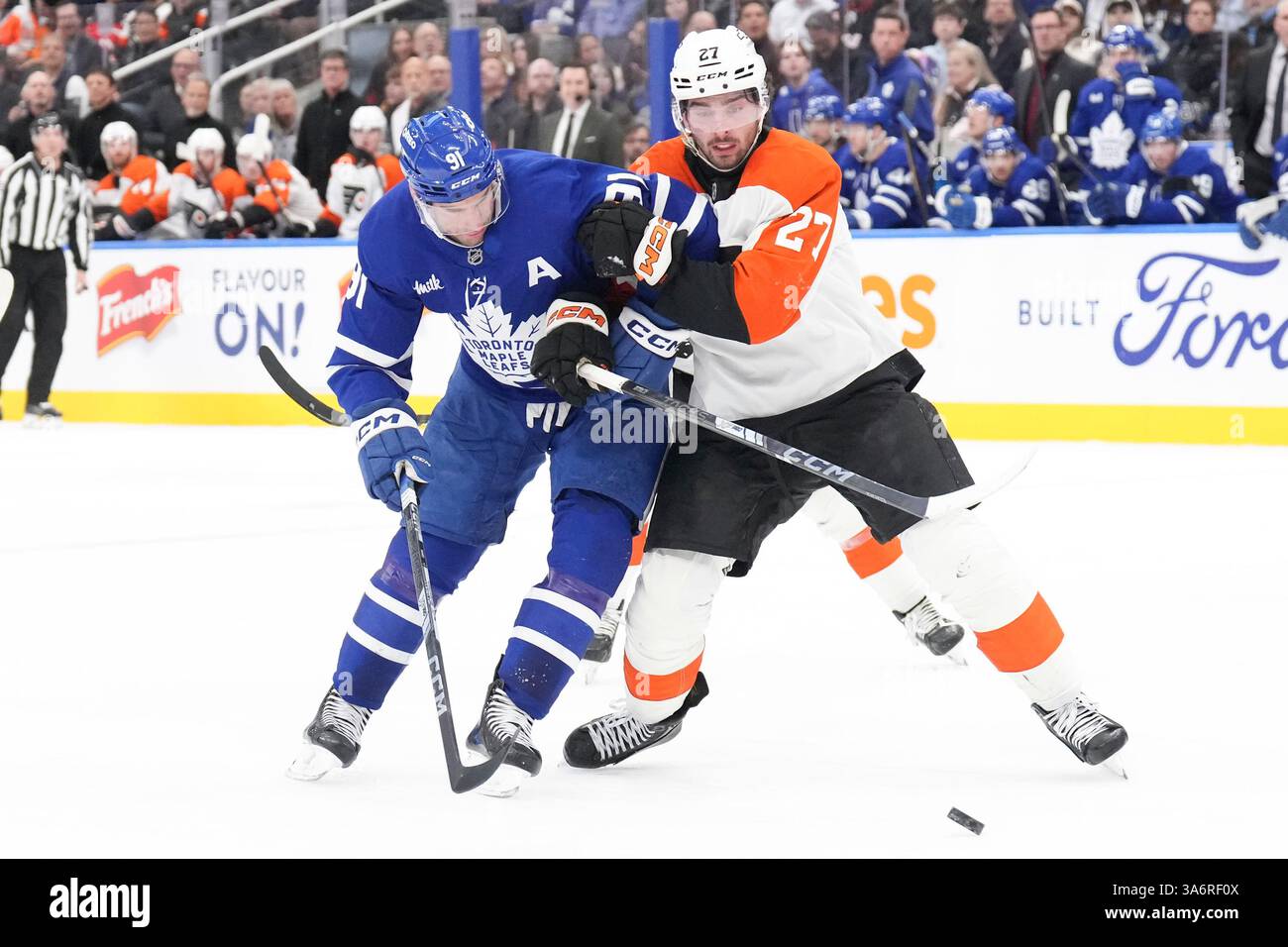 Philadelphia Flyers' Noah Cates (27) tries to hold off Toronto Maple ...