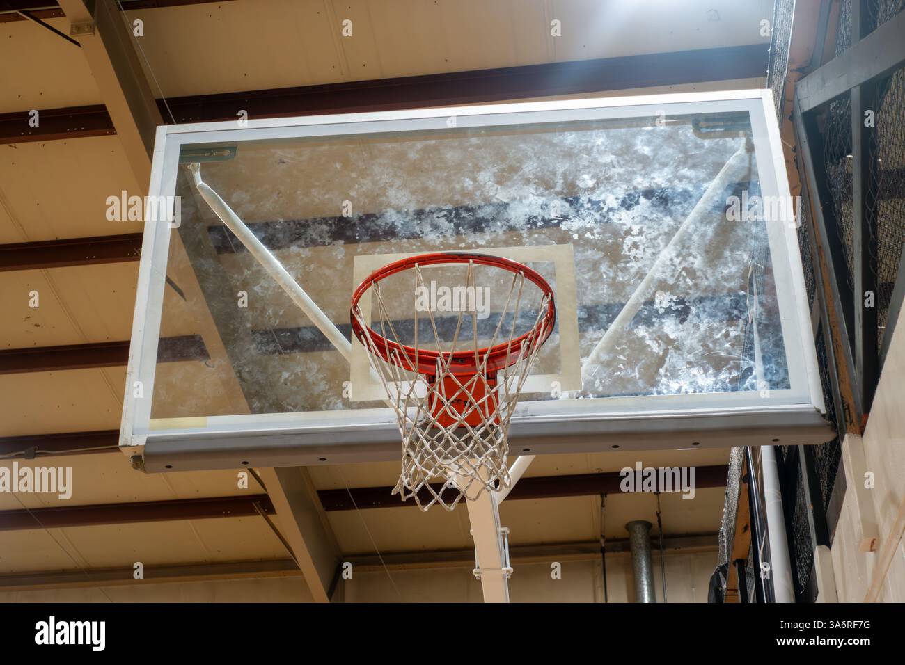 Players practice shooting at a basketball hoop in a gymnasium during ...