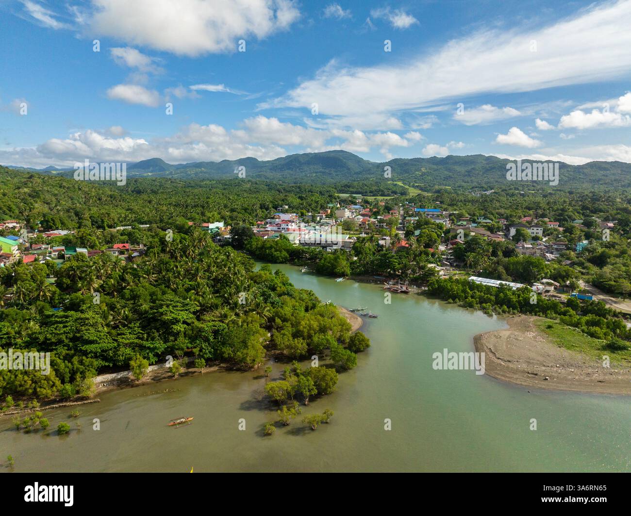 Tropical Island with houses and river. Looc, Poblacion. Blue sky and ...