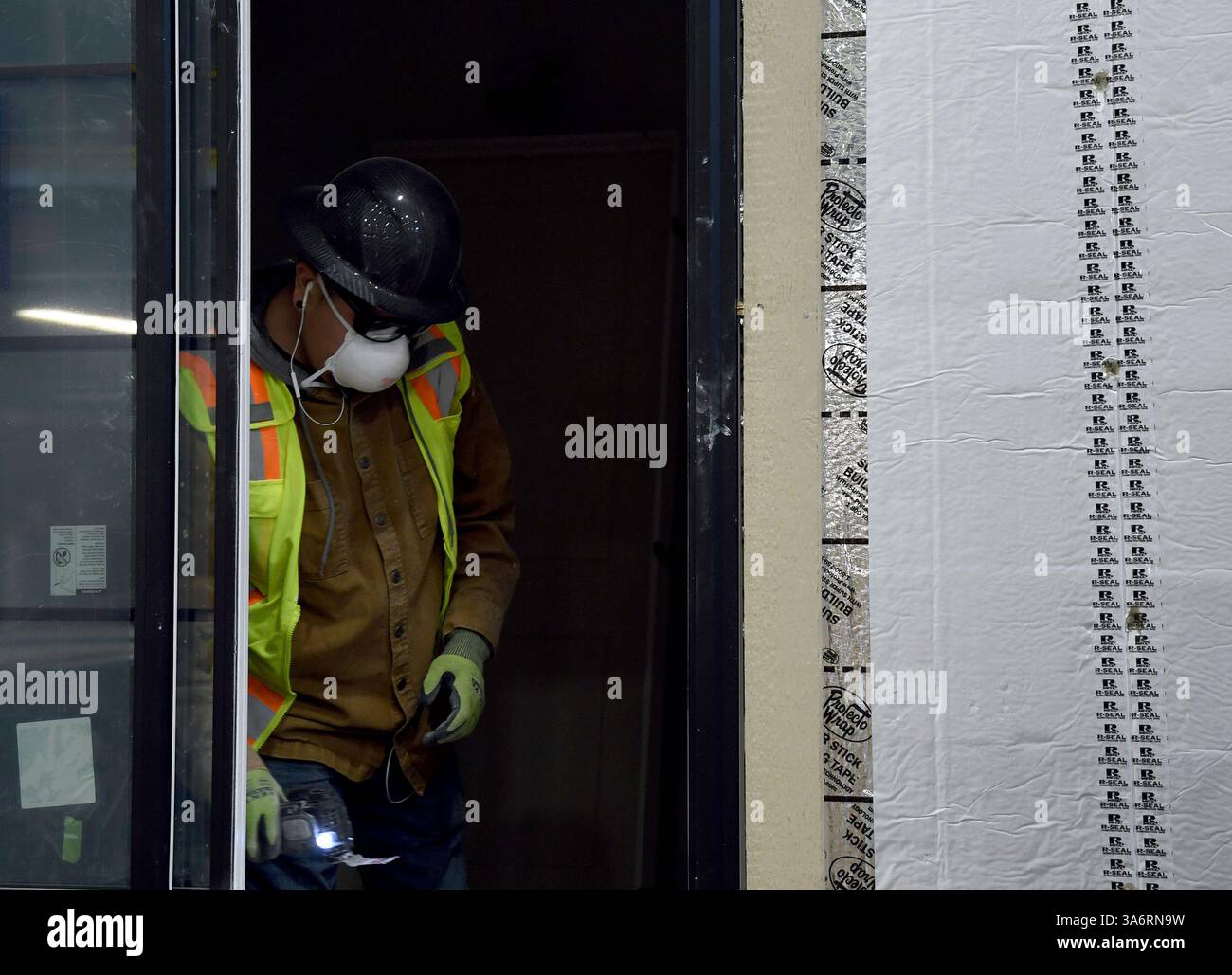 A worker constructs the window of a modular home at the Fading West ...