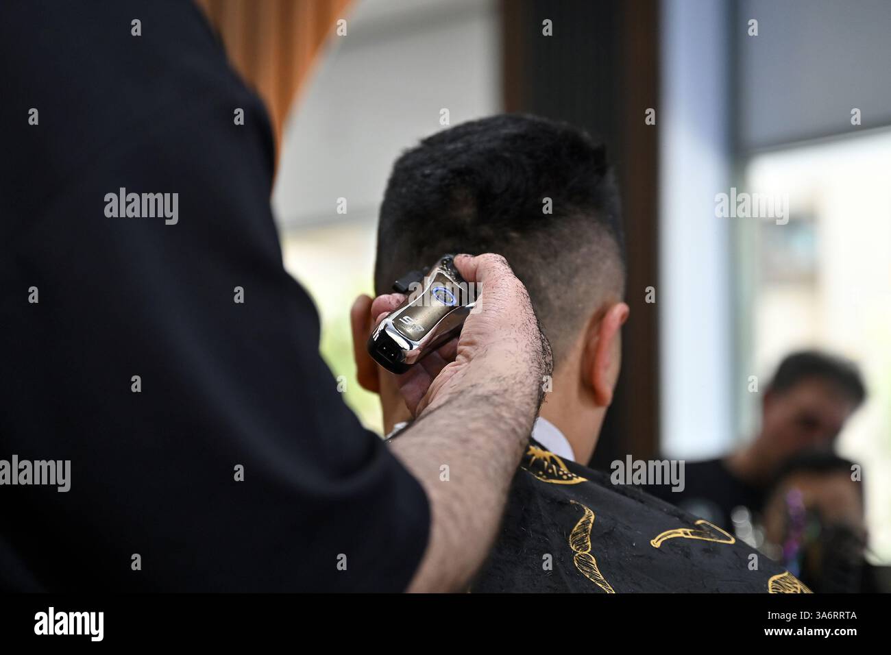 Sydney, Australia. 26th Mar, 2025. A man receives a haircut at Boston ...