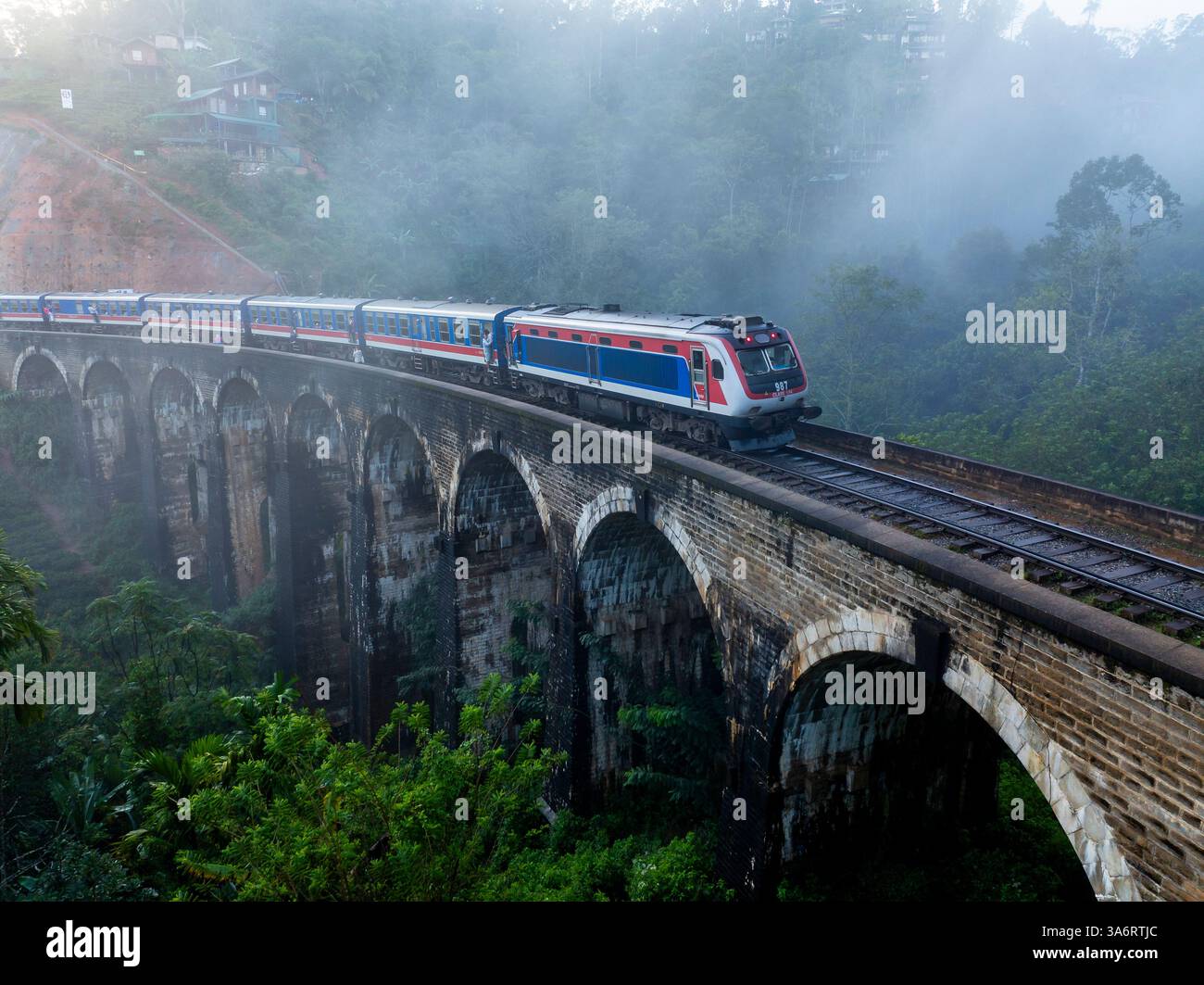A scenic train crosses the iconic Nine Arch Bridge in Ella, Sri Lanka ...