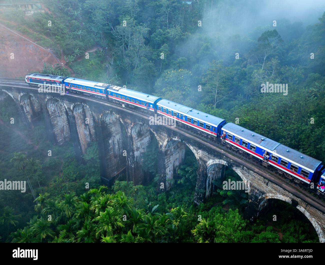 A scenic train crosses the iconic Nine Arch Bridge in Ella, Sri Lanka ...