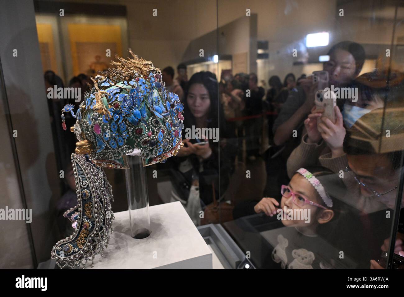 Beijing, China. 25th Mar, 2025. Visitors look at an empress crown from ...