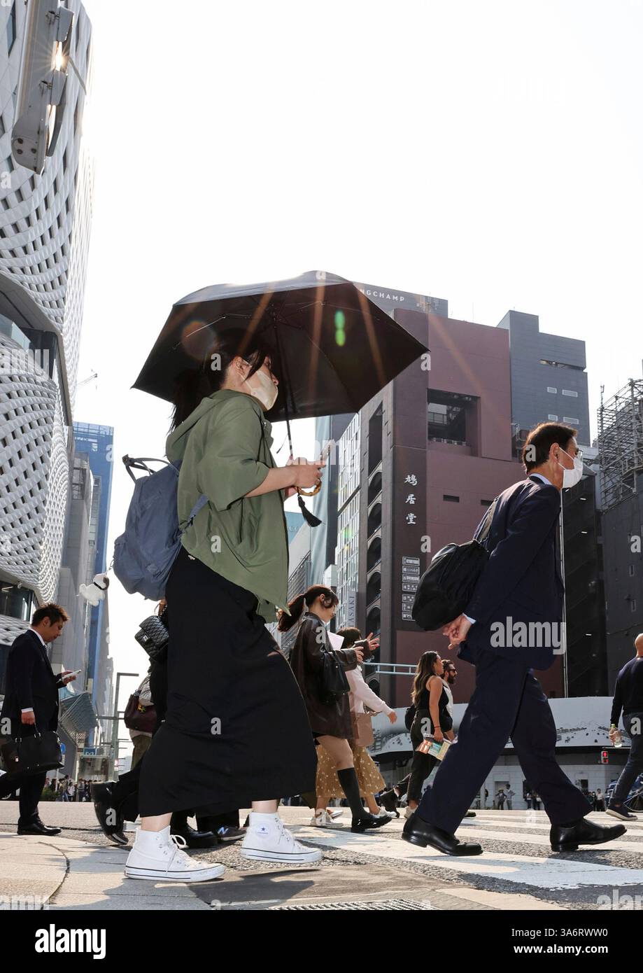People walk on a street while the temperature rises in Ginza, Tokyo on ...