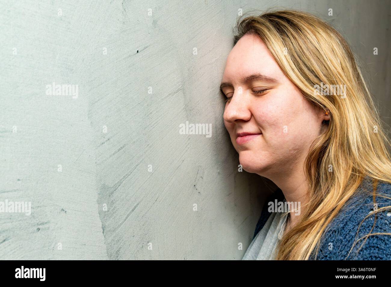 A beautiful adult woman with long hair reflects peacefully against a ...