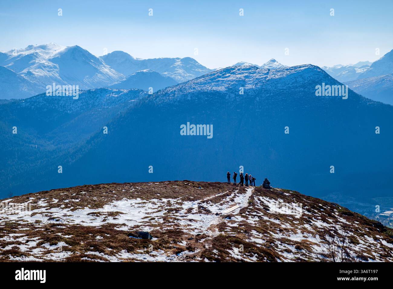 A group of adventurers stands at the top of a snowy mountain, enjoying ...