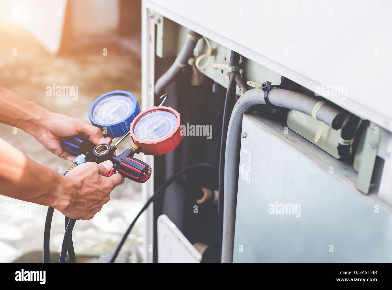 Air repair mechanic using measuring equipment for filling industrial ...