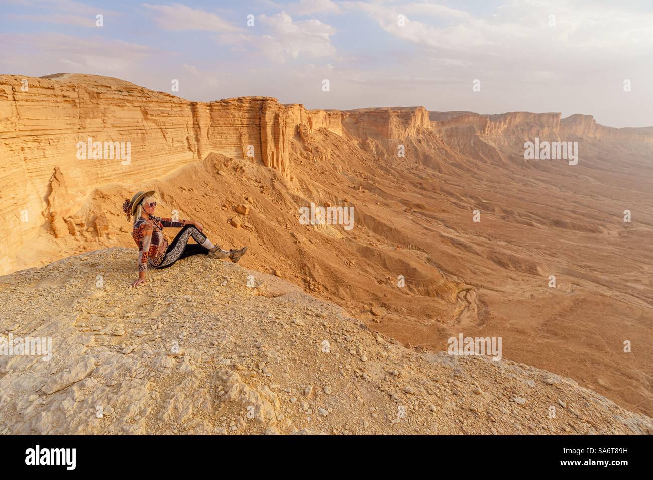 woman at sunset over the vast desert landscape viewed from the cliffs ...