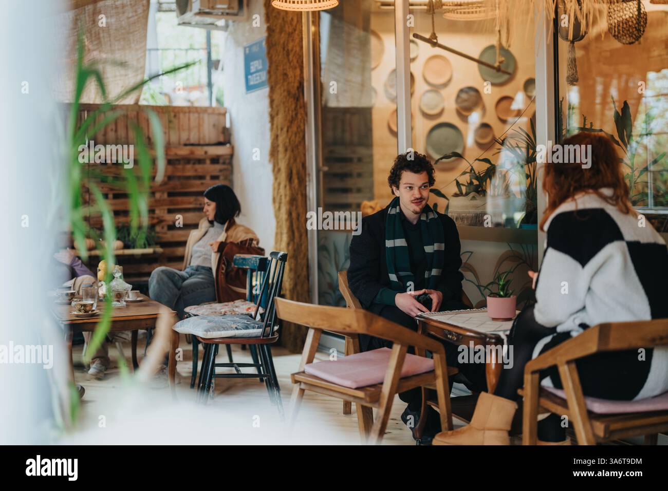 Casual coffee shop interaction with friends in a cozy modern interior ...