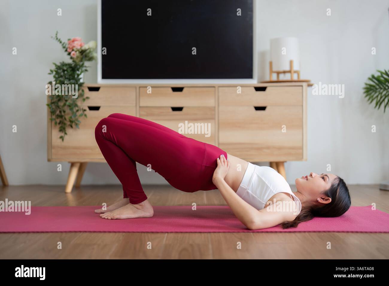 Yoga and Core Strength. A woman practicing bridge pose for ...