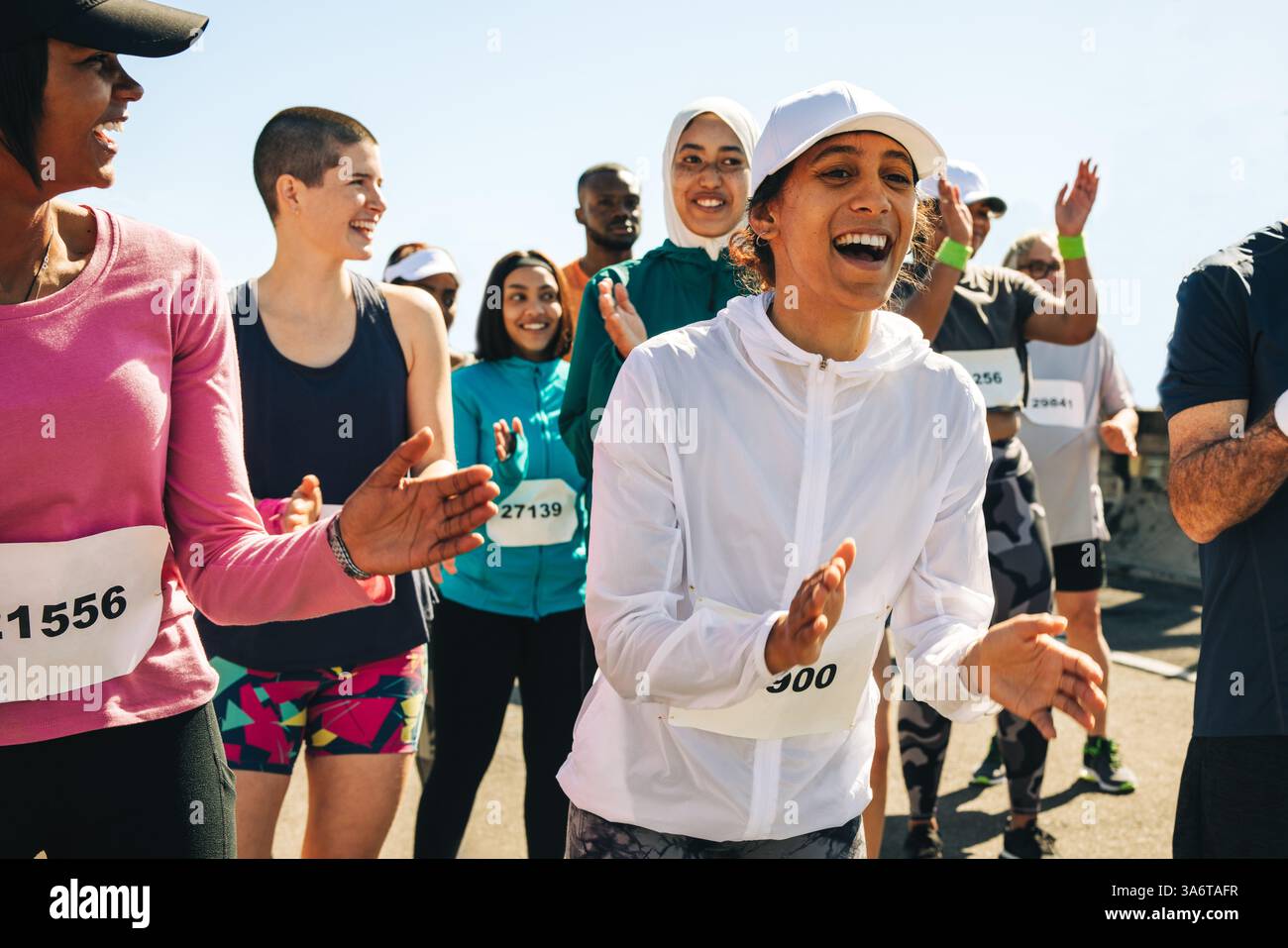 A group of diverse runners celebrates after participating in a ...