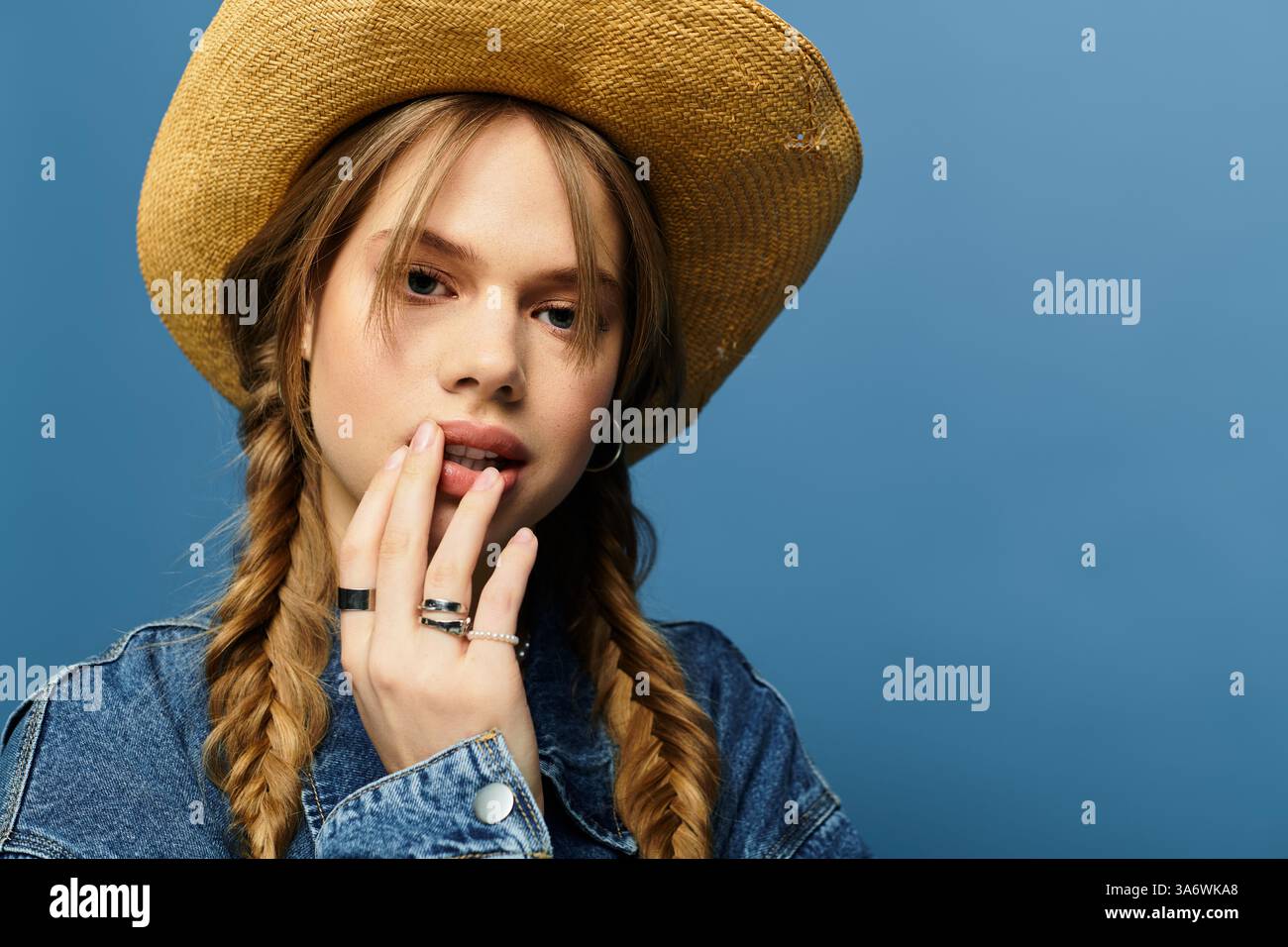 A young woman poses playfully in a stylish denim jacket in a spring ...
