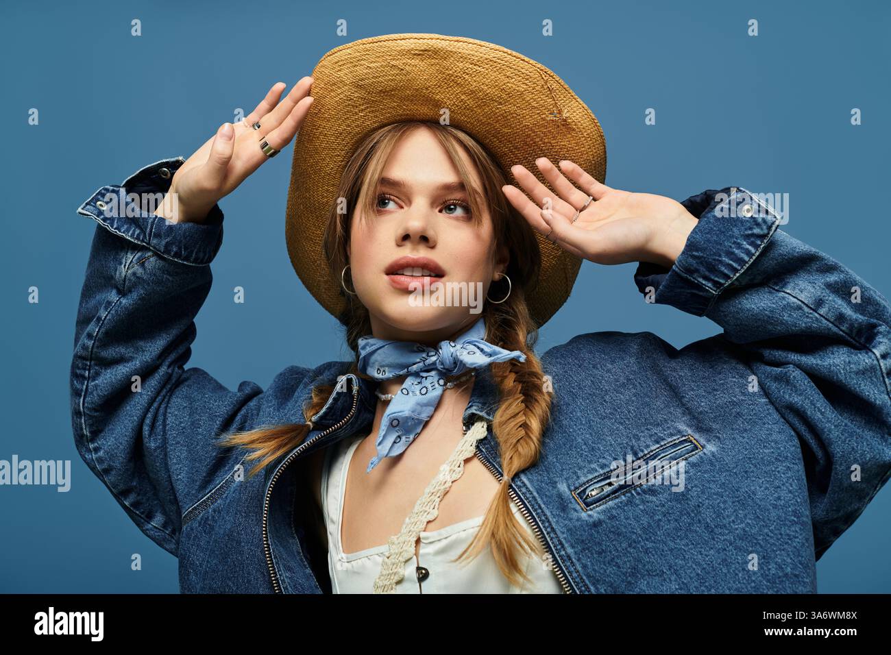 A young woman in a chic denim jacket celebrates spring with a joyful ...