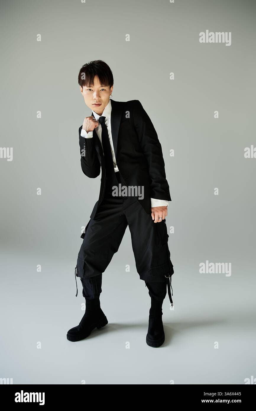 A handsome young asian man showcases his unique style in a sleek outfit ...