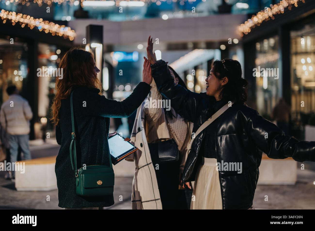 Friends Socializing at Night on a City Street During Festive Season ...