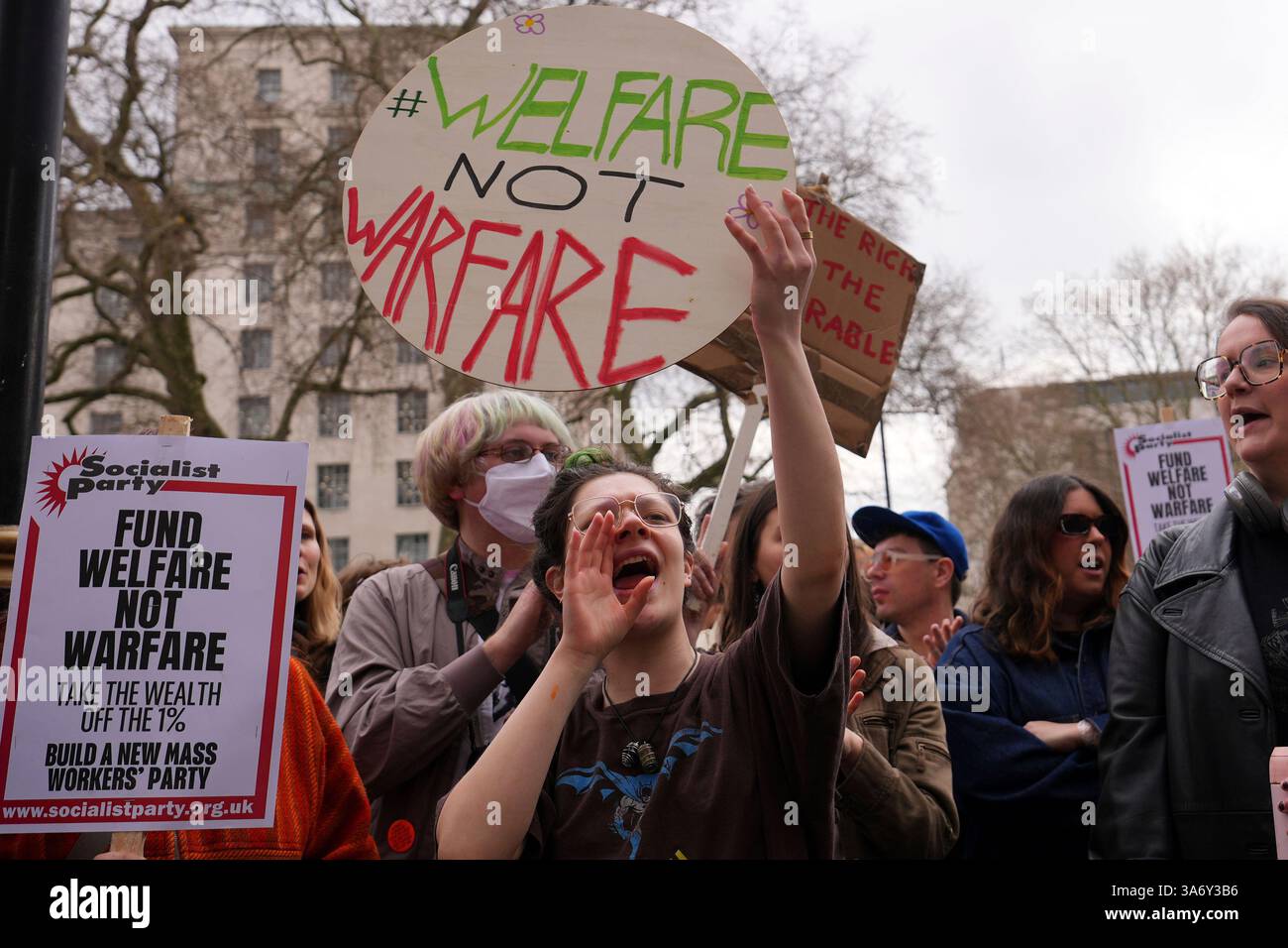 Protesters show placards as Britain's Chancellor Rachel Reeves is about ...