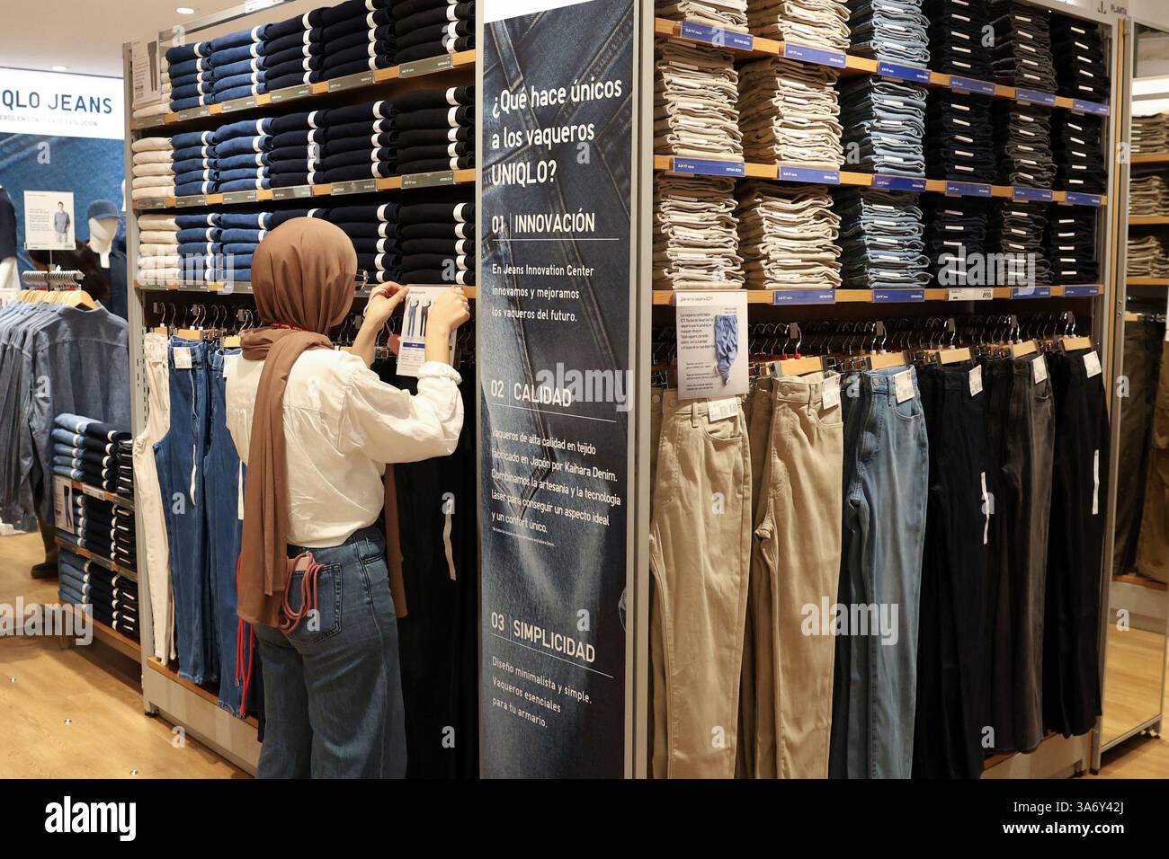 A sales clerk places clothes at Uniqlo's new flagship store in Madrid ...