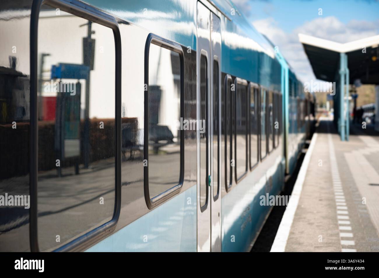 Covered platform with waiting shiny train at a station in the ...