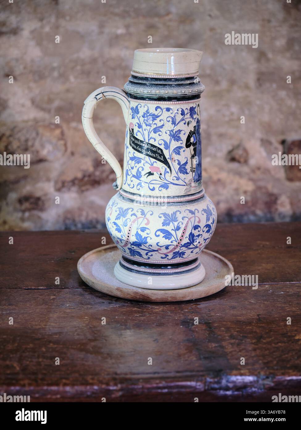 A traditional ceramic beer stein with blue floral patterns, placed on a ...