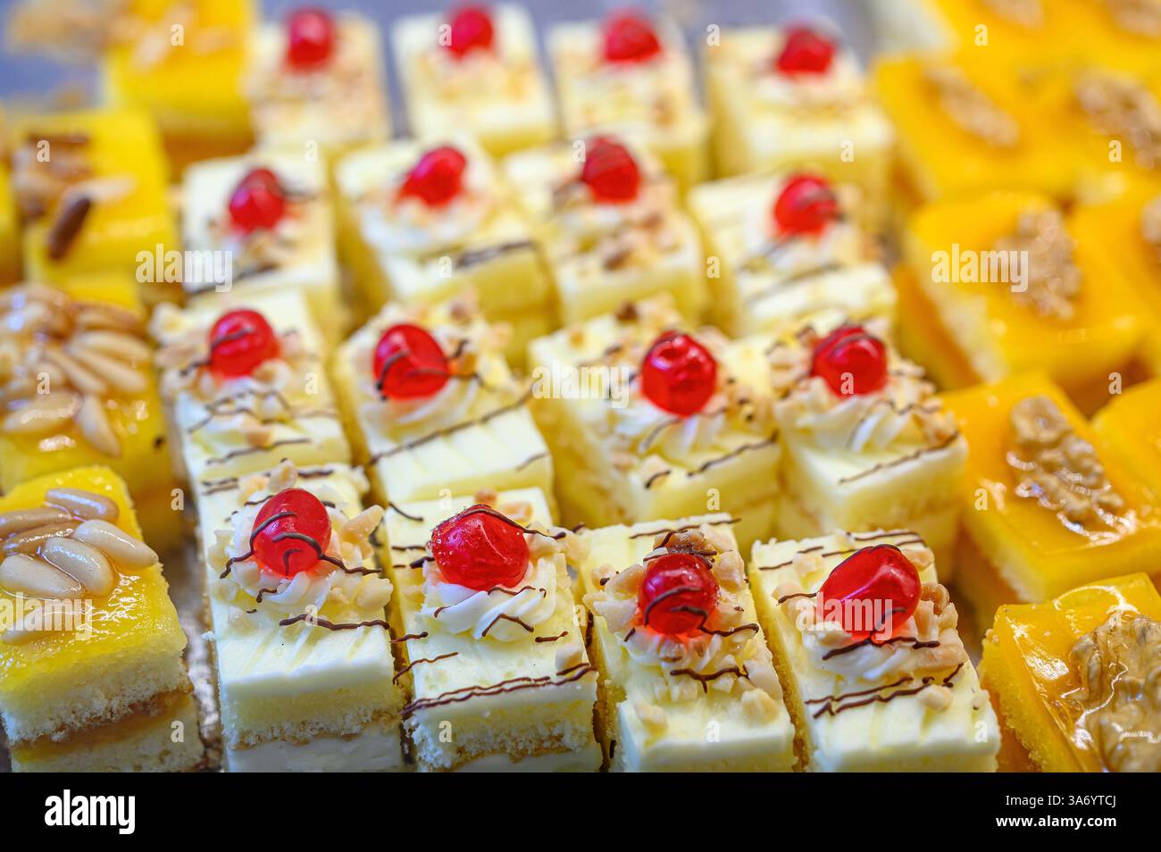 A group of pastries topped with cherries in a retail display Stock ...