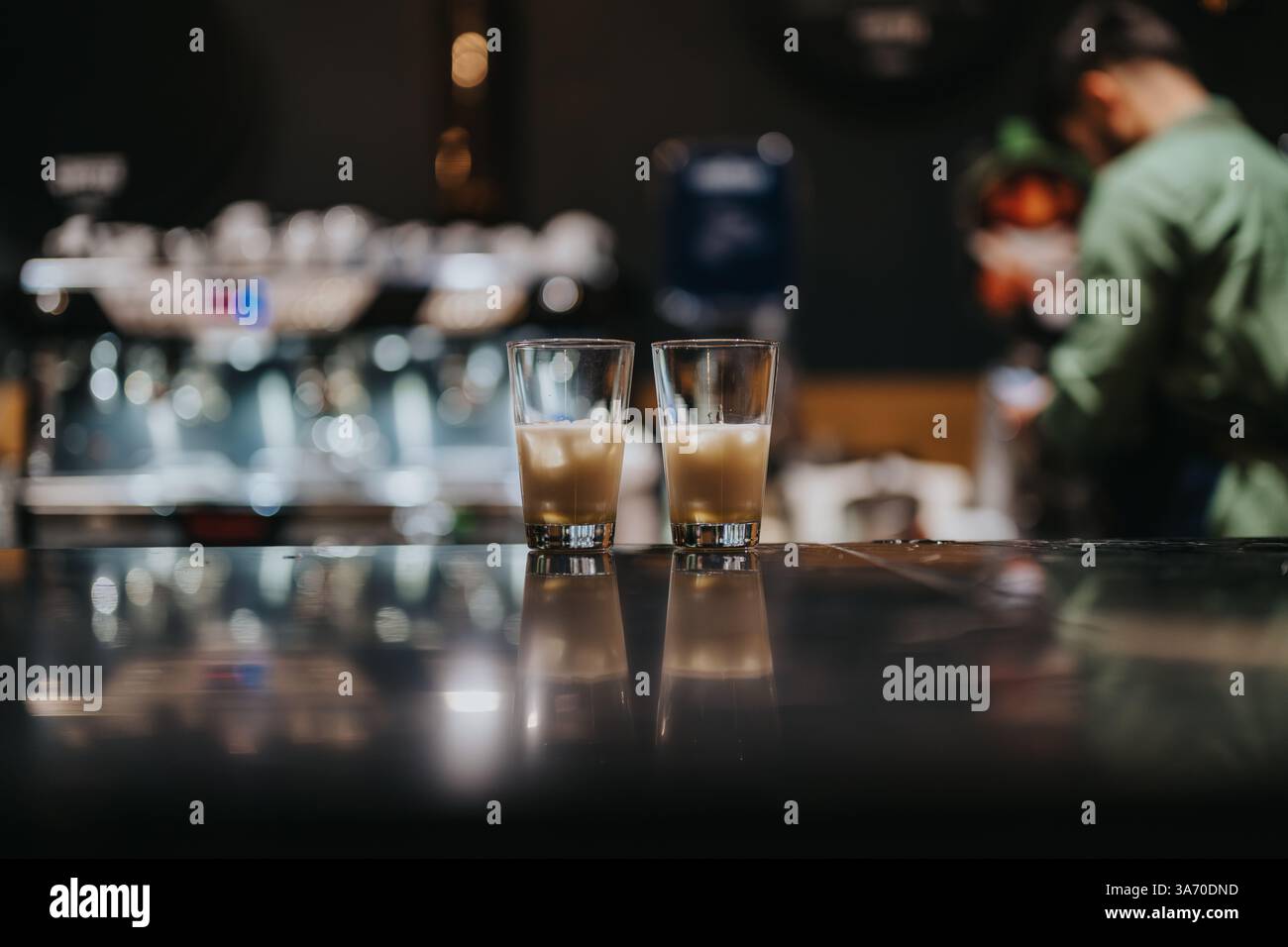 Two dairy-based beverages with blurred barista and cafe background ...