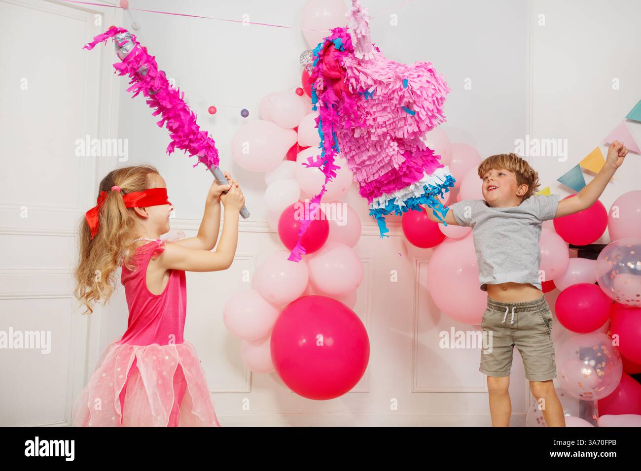 Children playfully hit and swing unicorn pinata having party fun Stock ...