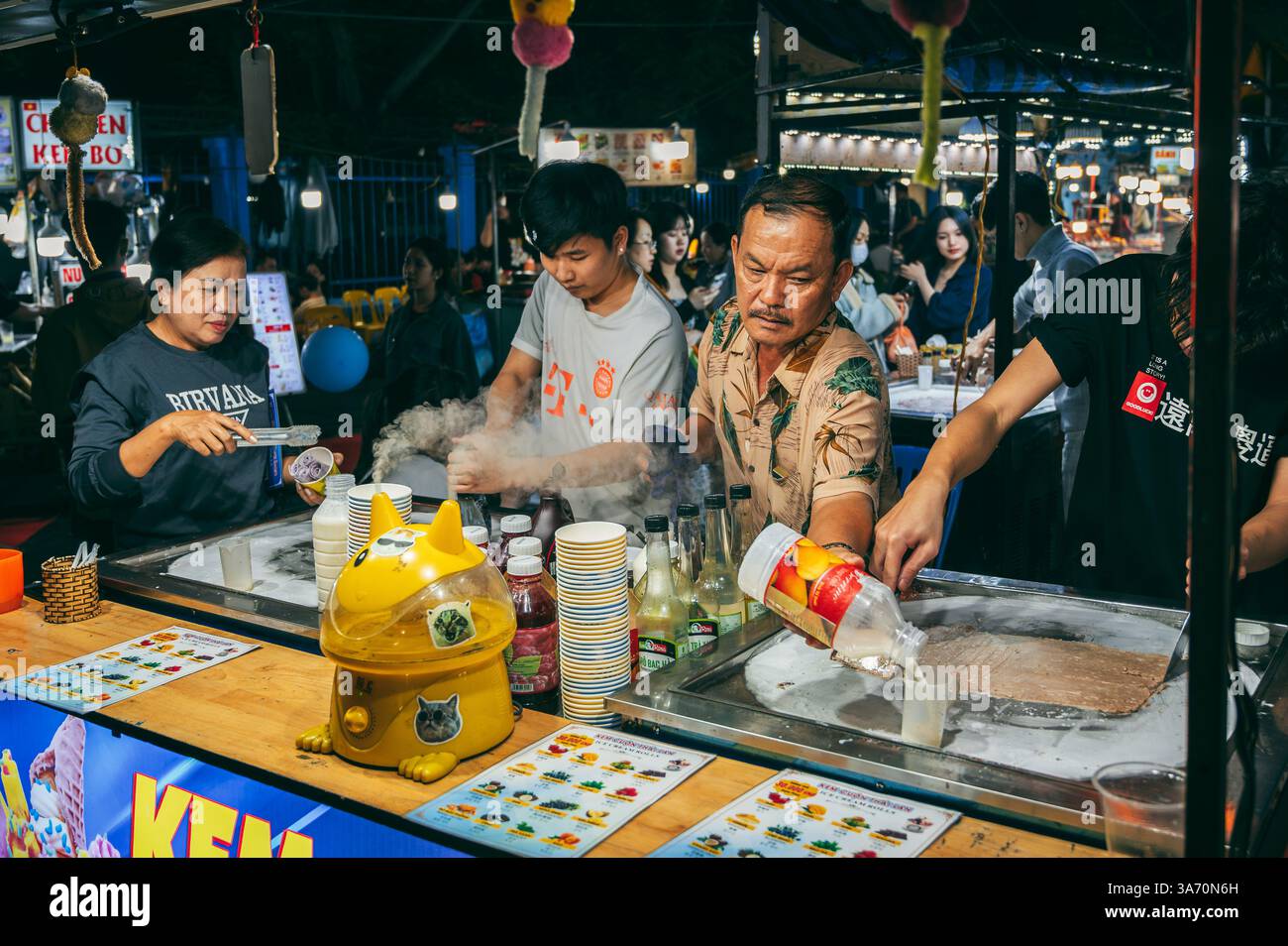 Vietnamese chefs and vendors make ice cream at a asian Night market of ...