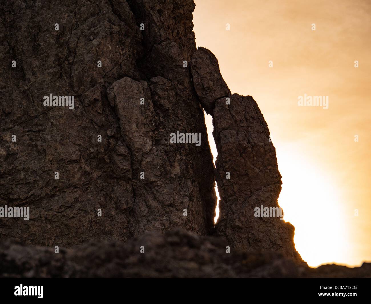 Sunset behind a natural leaning stone structure min the triglav Stock ...
