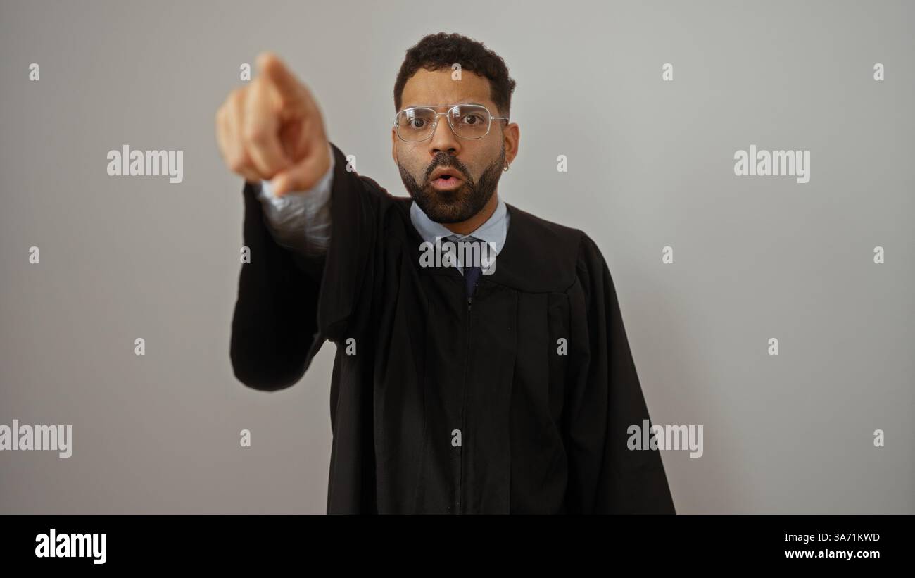 Young, hispanic, man in judge attire standing against an isolated ...