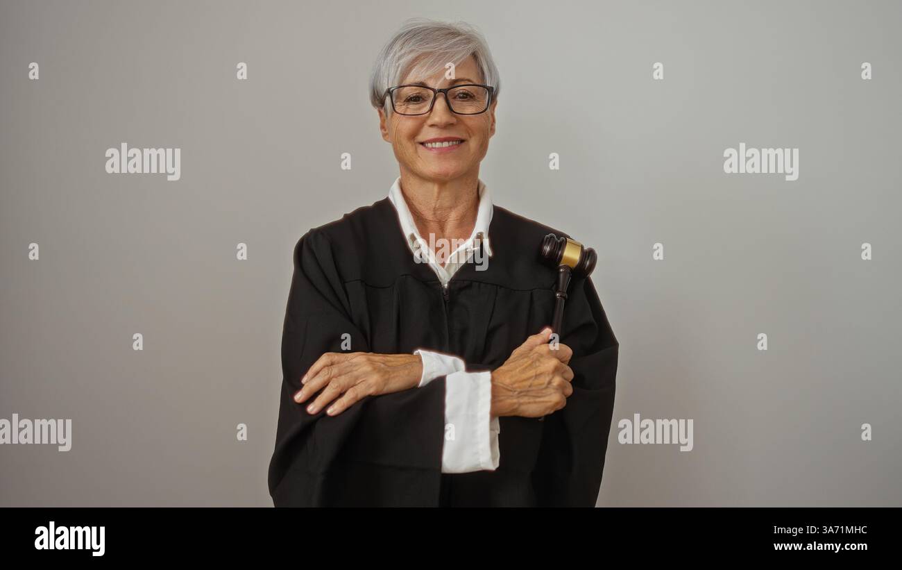 Mature judge woman with short grey hair and glasses stands with arms ...