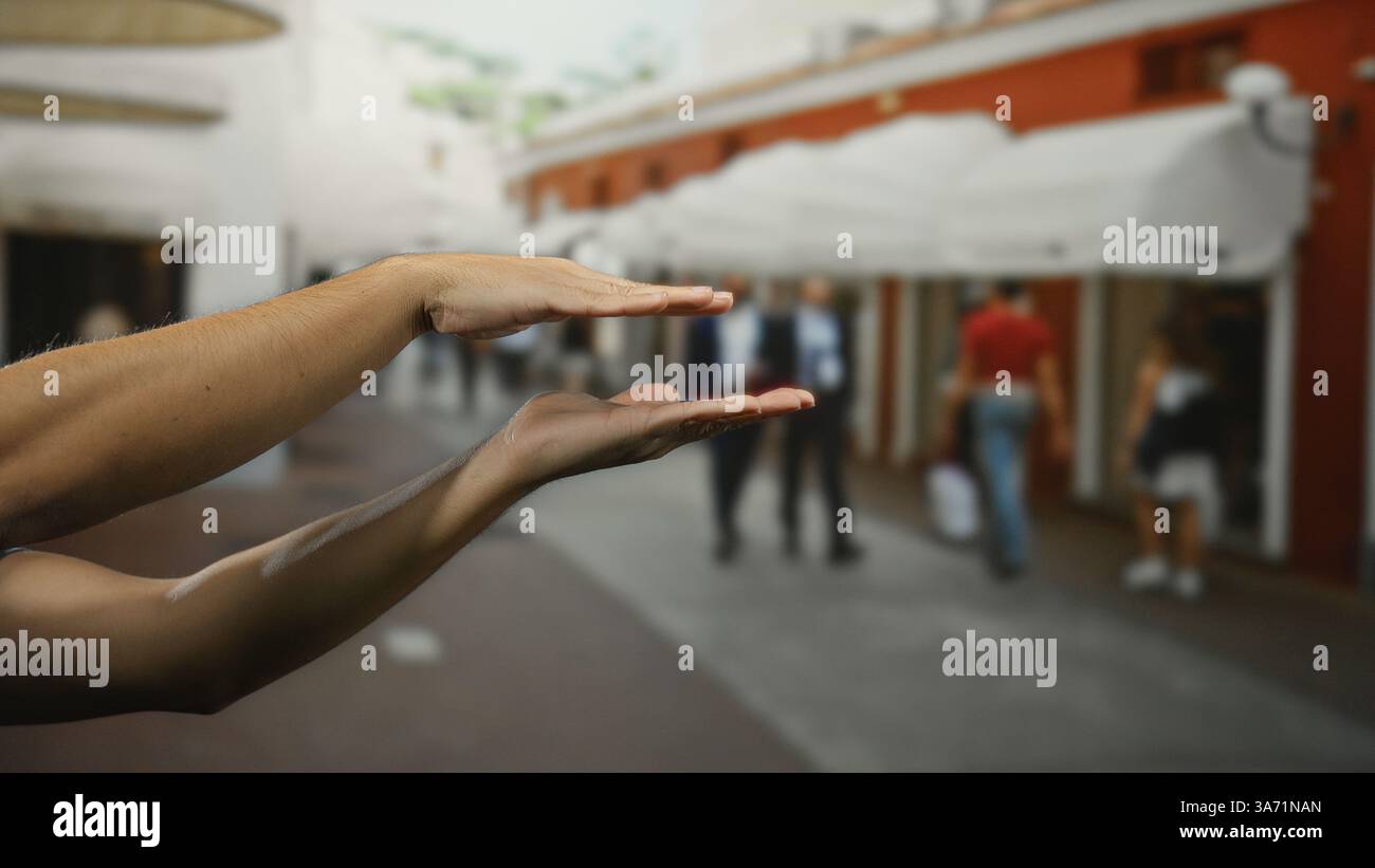 Hands of a man creating a frame gesture on a bustling urban city street ...
