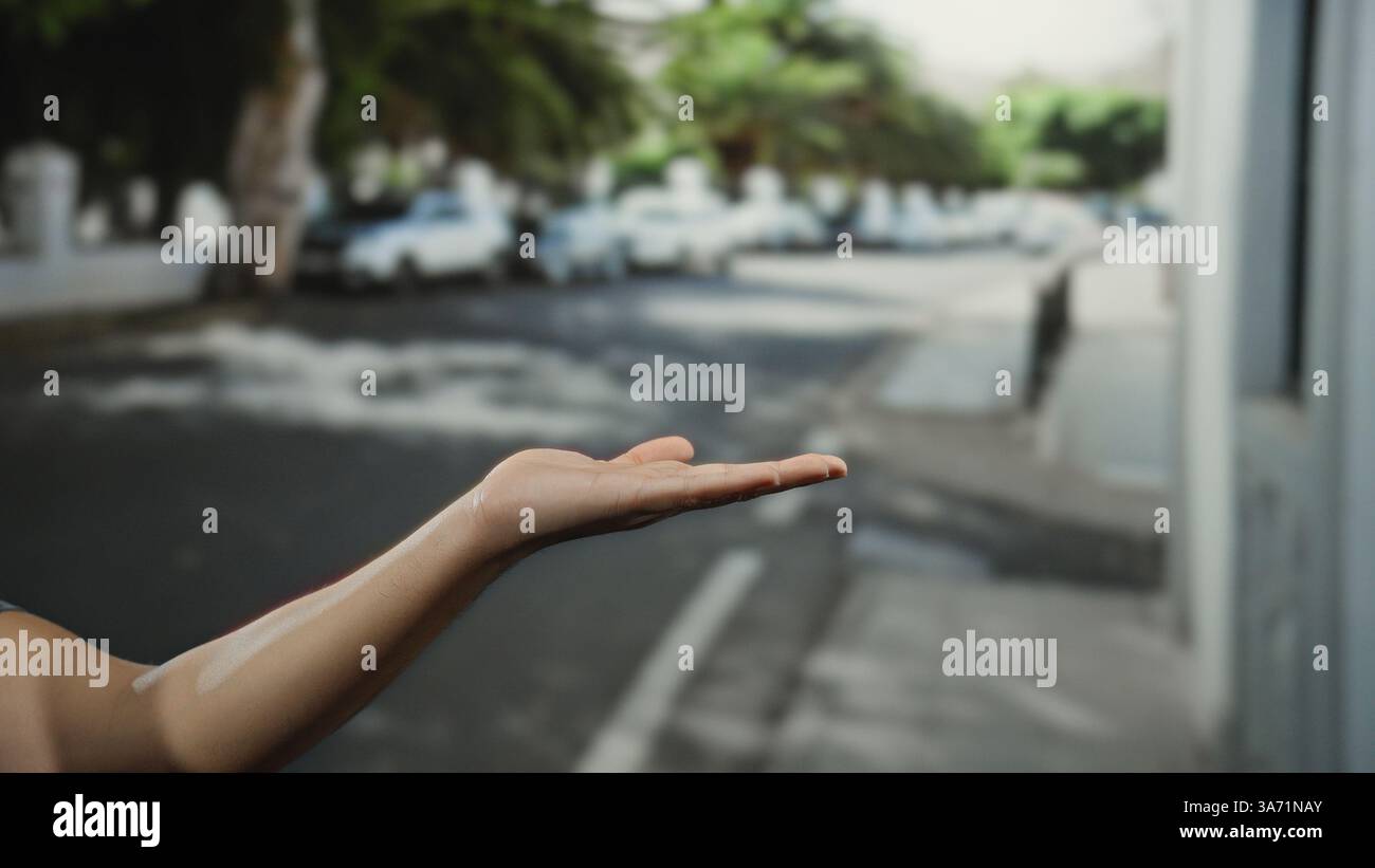 Man extends hand on a city street, showcasing a gesture that blends ...