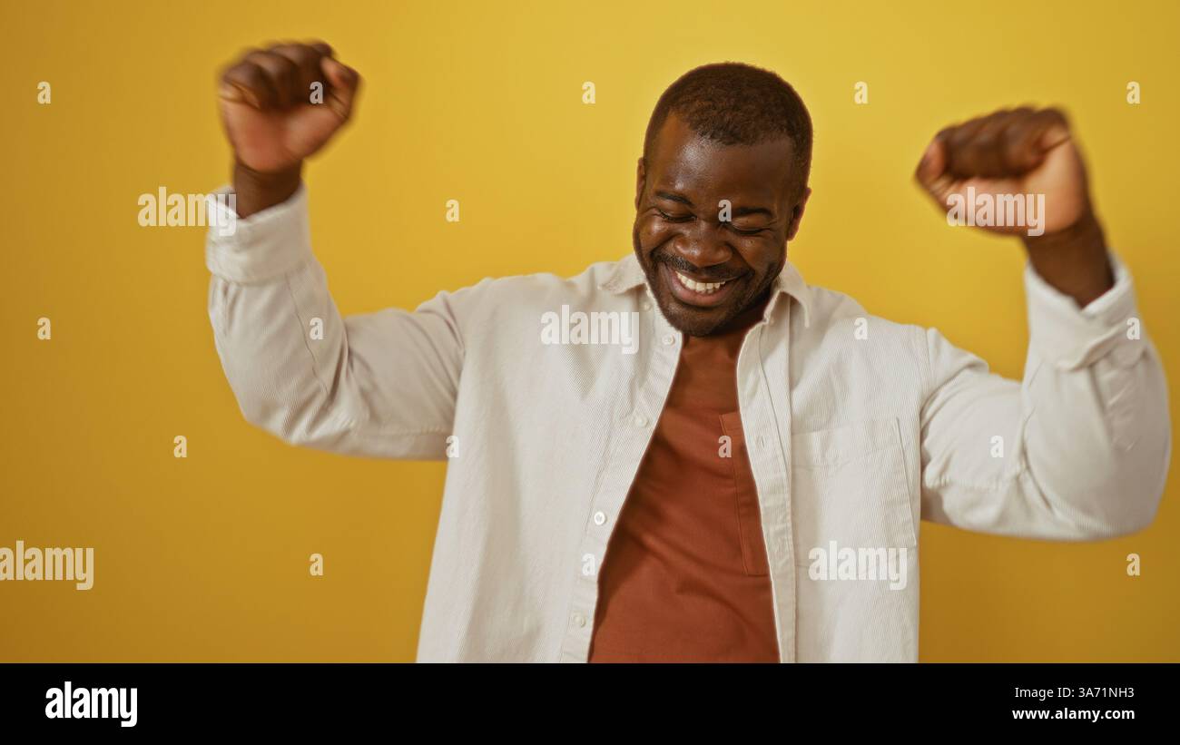 Happy man celebrating over isolated yellow background, conveying joy ...
