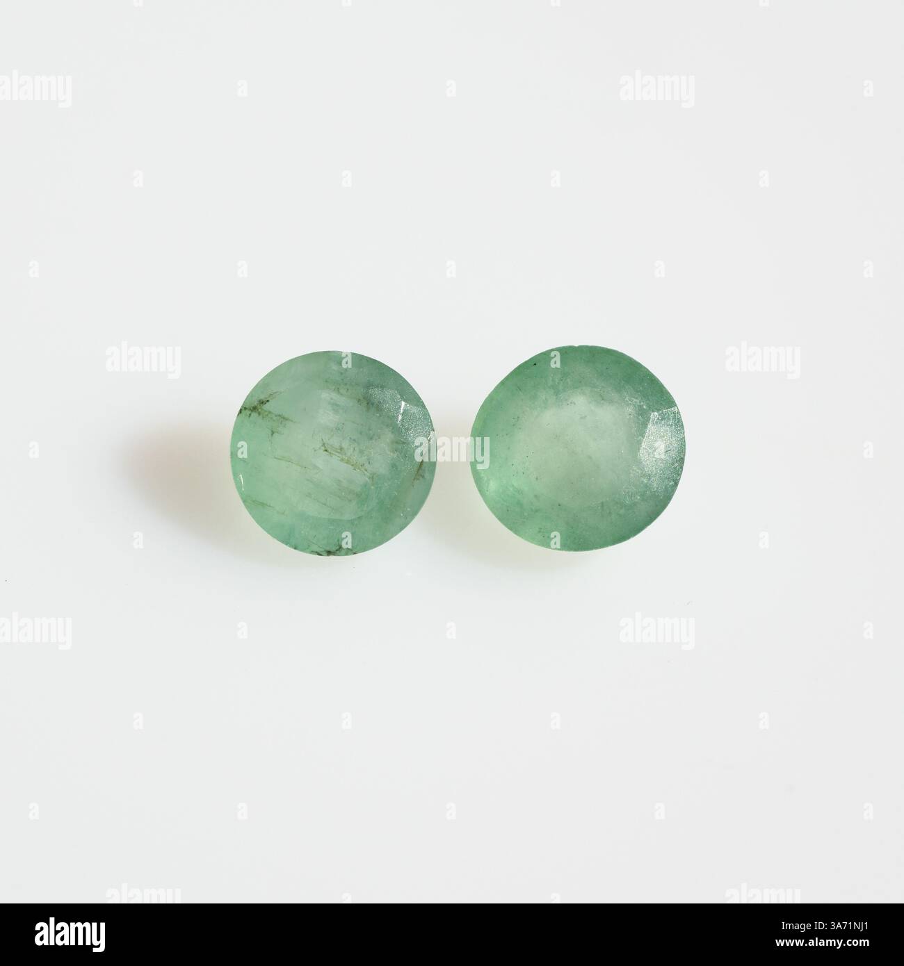Close-up of Two Faceted Natural Emerald Gemstones Against a Clean White ...